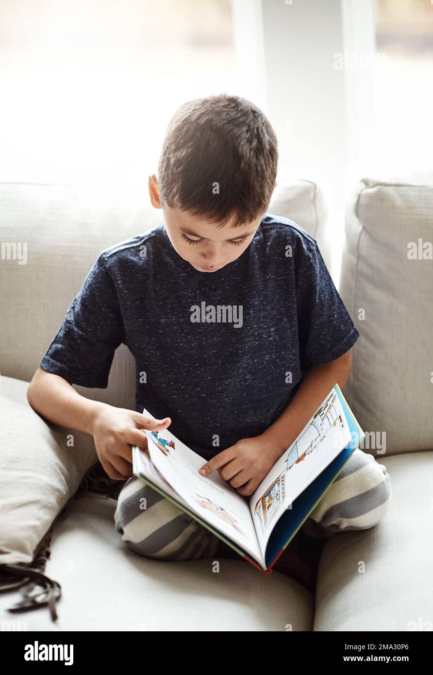 Hobby, boy and reading on sofa, relax and happy on weekend, break and ...