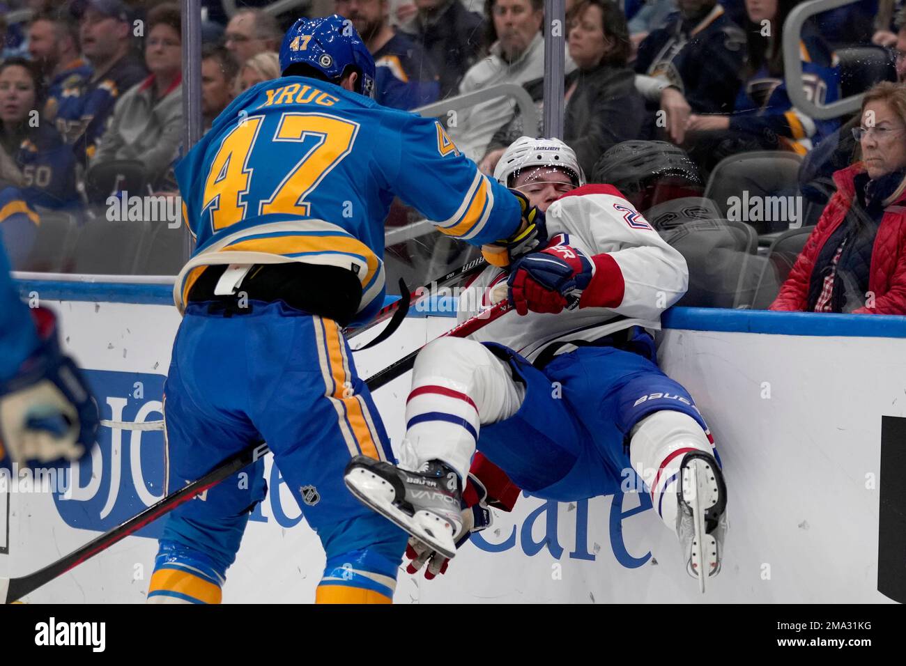 Montreal Canadiens' Cole Caufield, right, is checked into the boards by ...