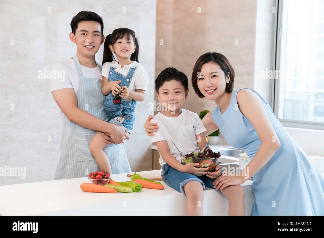 Happy family of four cooking in the kitchen Stock Photo - Alamy