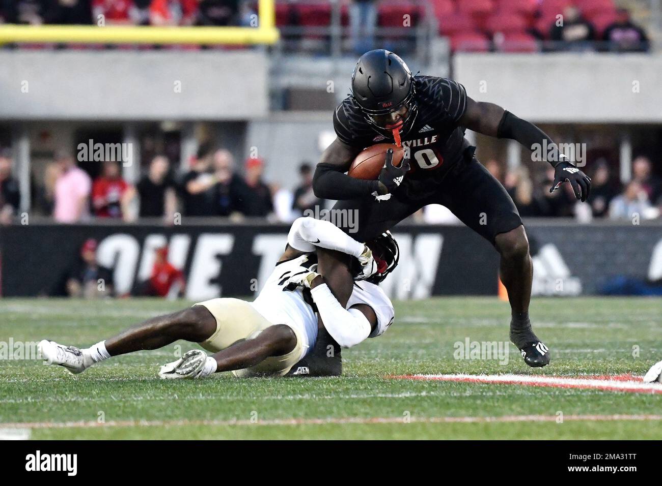 Wake Forest defensive back DaShawn Jones, bottom, grabs the leg of Louisville wide receiver ...