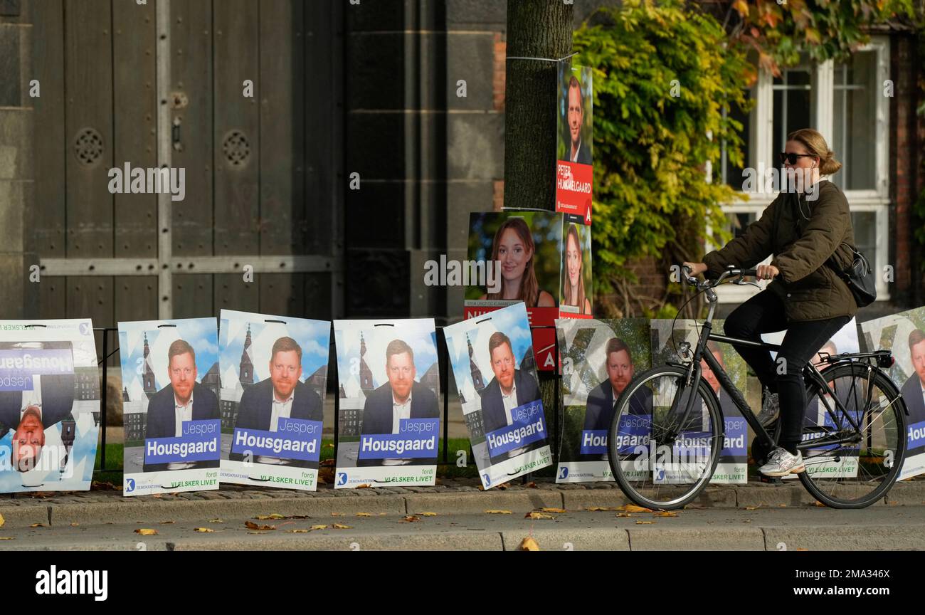 A woman on bicycle passes by election campaign posters in downtown ...