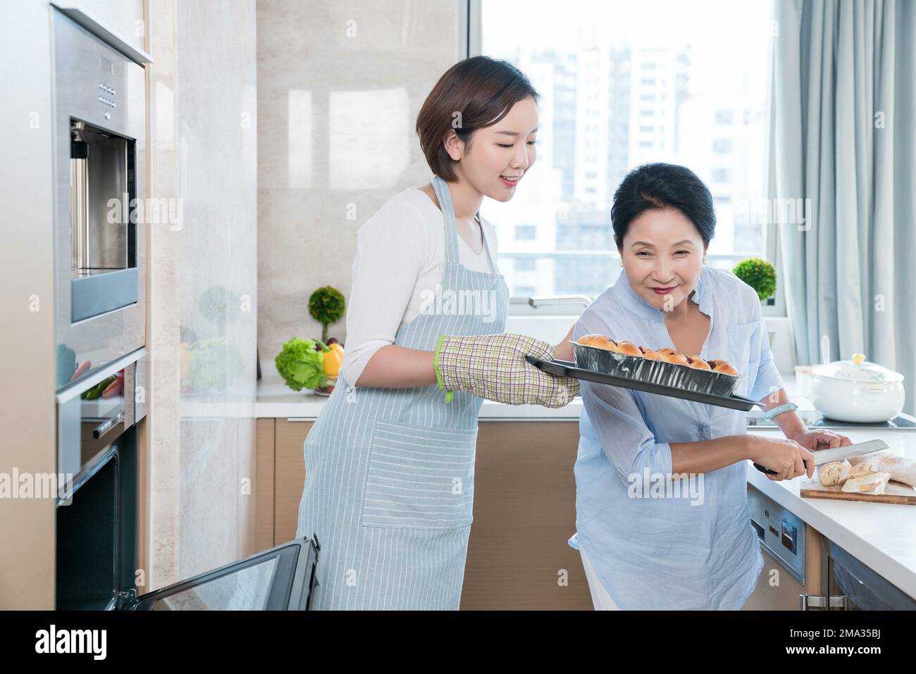 Mother and daughter two people bake bread in the kitchen Stock Photo ...