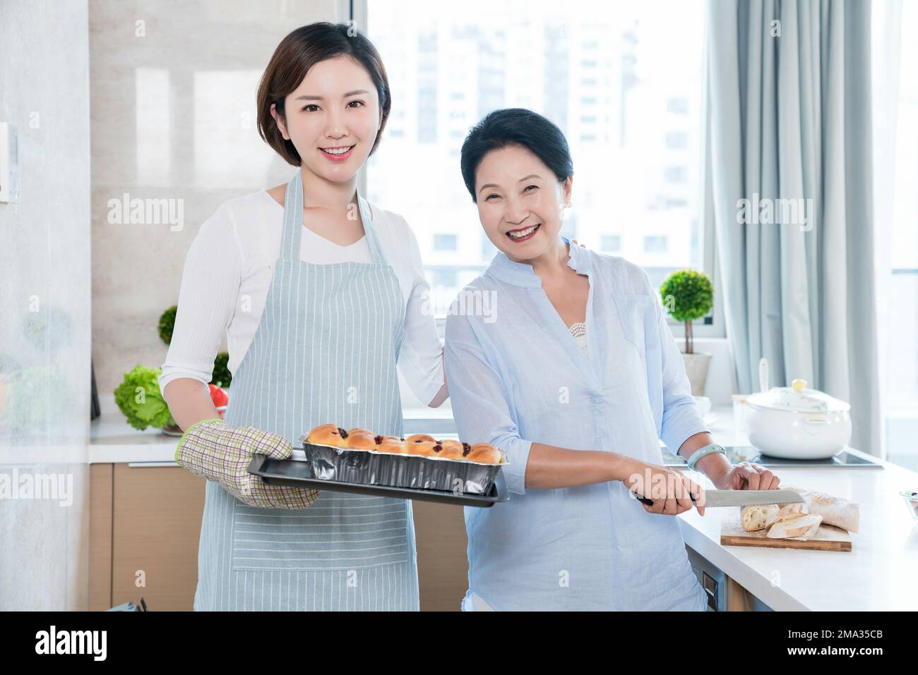 Mother and daughter two people bake bread in the kitchen Stock Photo ...