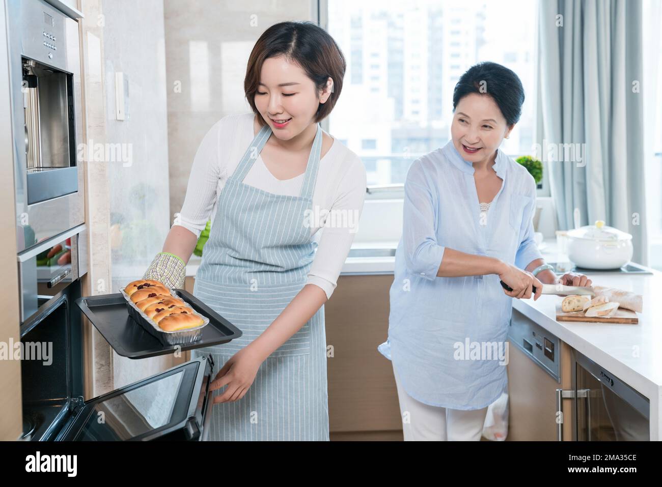 Mother and daughter two people bake bread in the kitchen Stock Photo ...