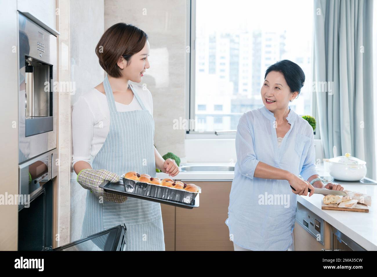 Mother and daughter two people bake bread in the kitchen Stock Photo ...