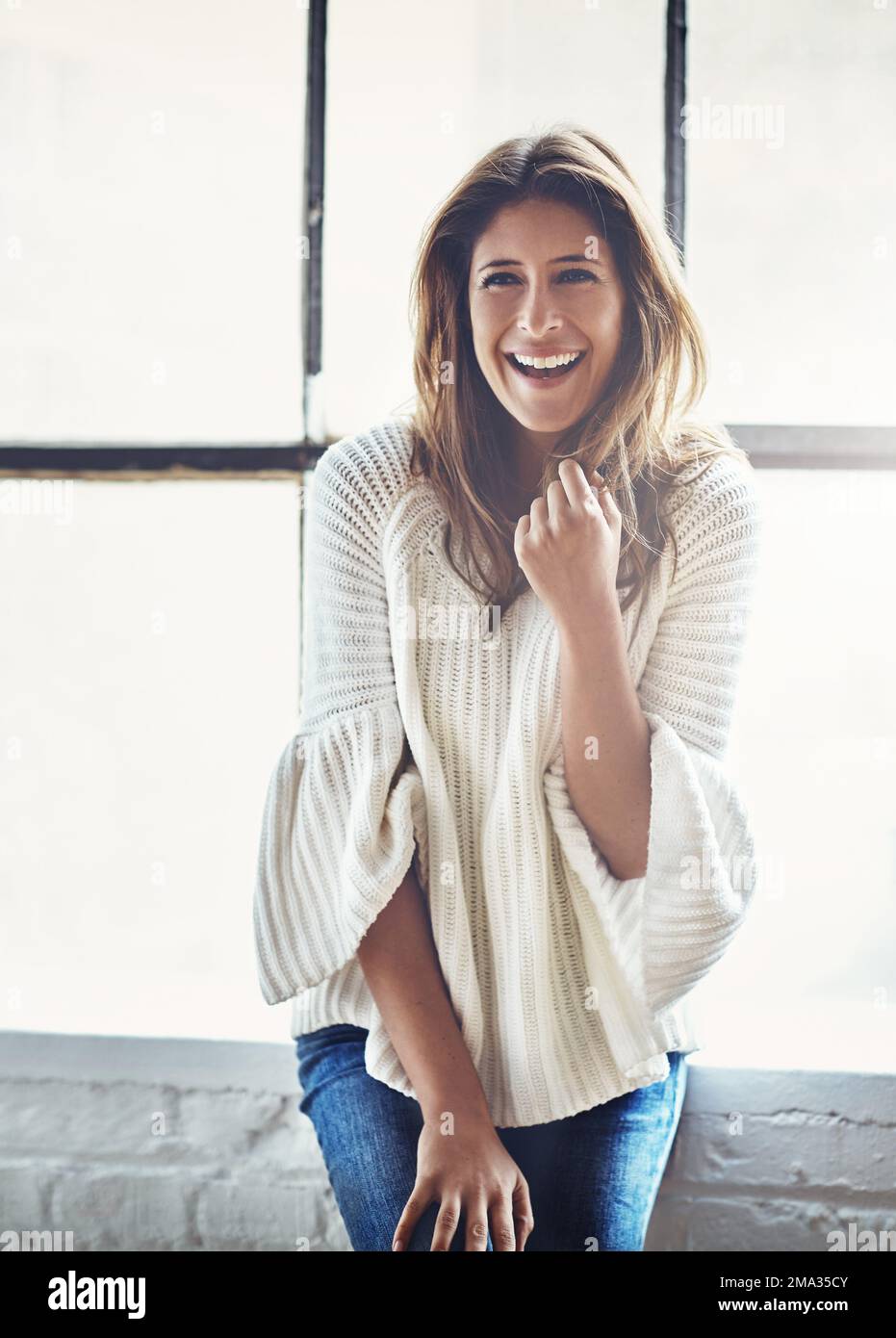 Portrait, happy and woman relax against a window in her home, content ...