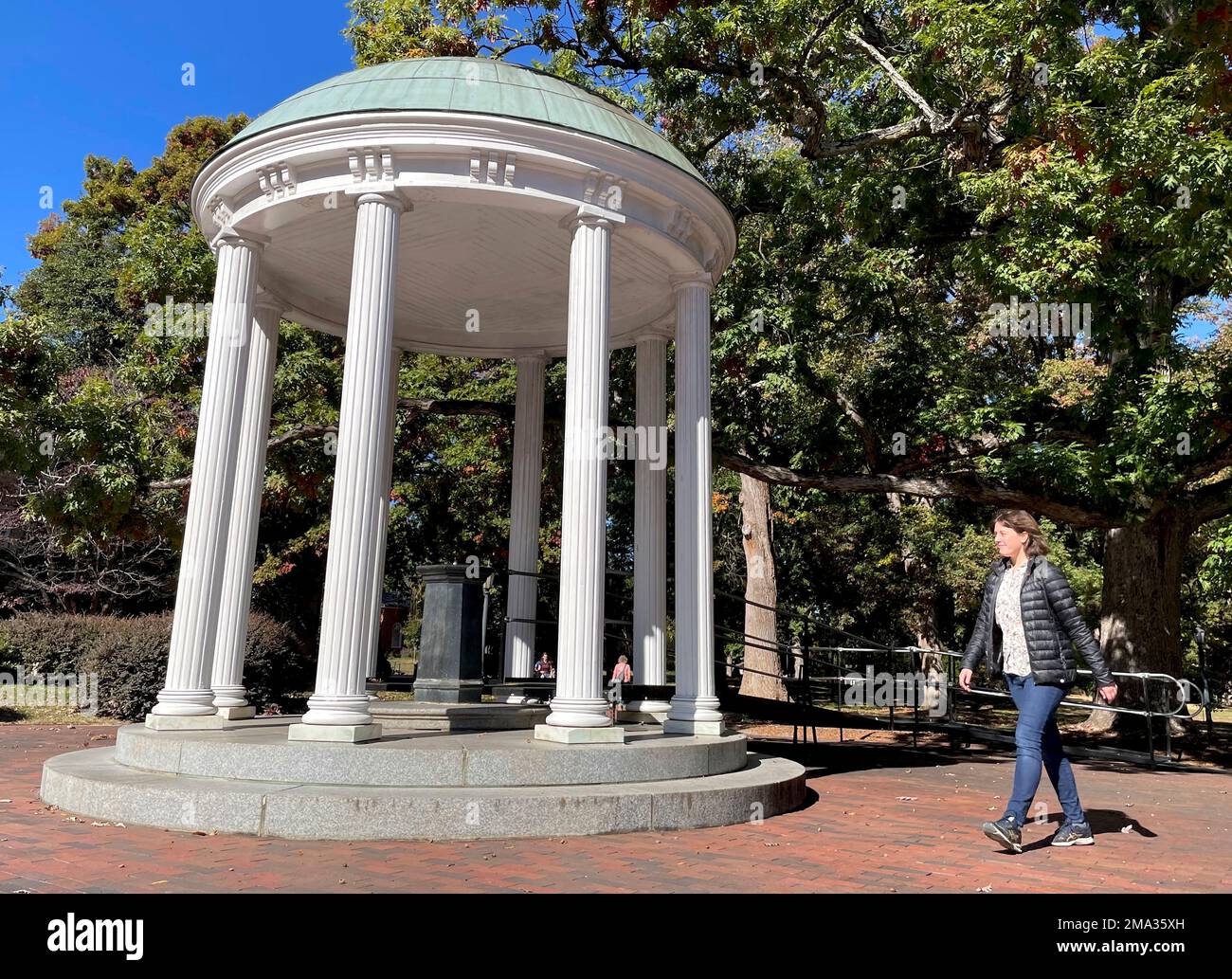 A student walks by the Old Well at the University of North Carolina at ...