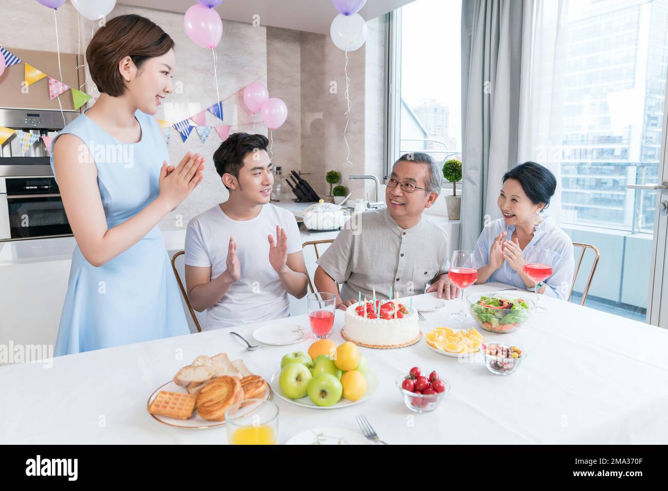 Happy family party to celebrate in the kitchen Stock Photo - Alamy