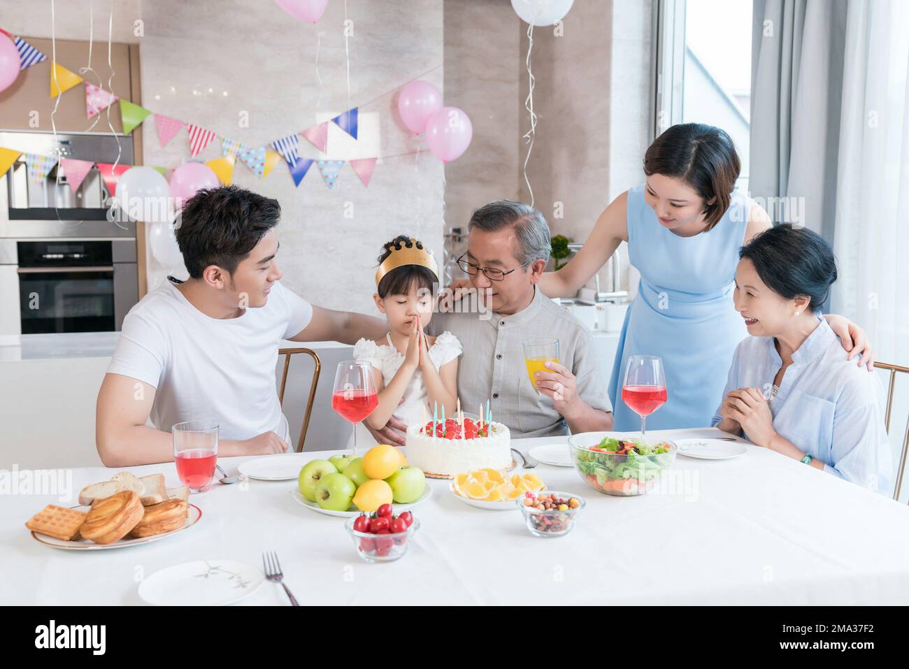 Happy family party to celebrate in the kitchen Stock Photo - Alamy