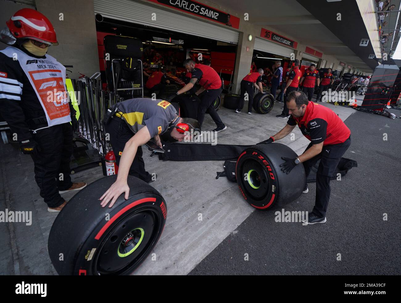 The pit crew of Ferrari driver Carlos Sainz, of Spain, prepare tires ...