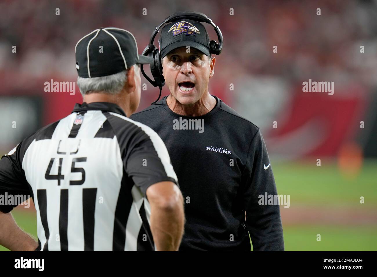 Baltimore Ravens head coach John Harbaugh speaks with line judge Jeff ...
