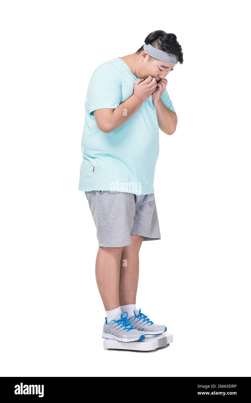 Obese young man weight measurement Stock Photo - Alamy