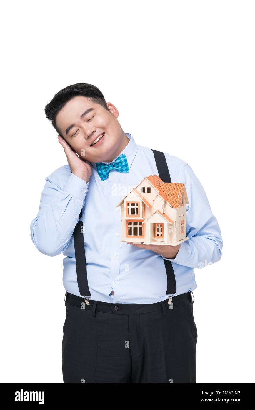 Obese young man with a house model Stock Photo - Alamy
