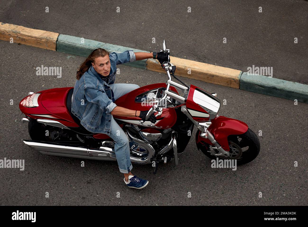 A man on a motorcycle rides in an urban landscape among concrete ...