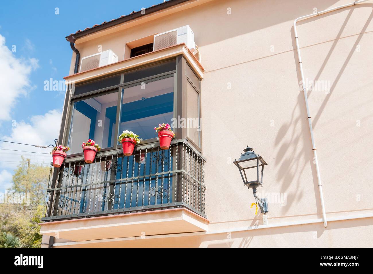 glazed balcony with red flowerpots Stock Photo - Alamy
