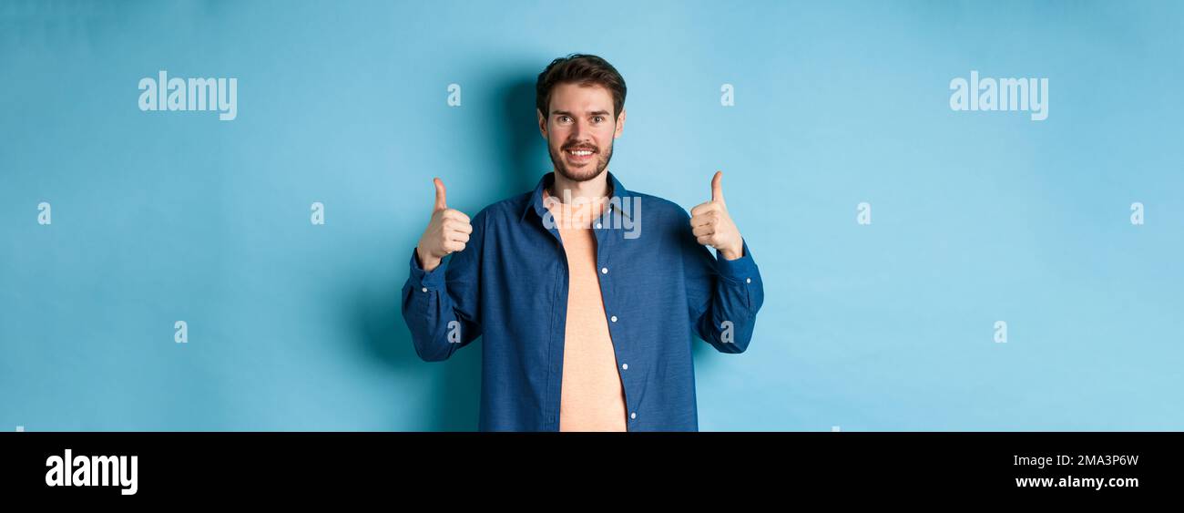 Handsome smiling man being supportive, showing thumbs up in approval ...