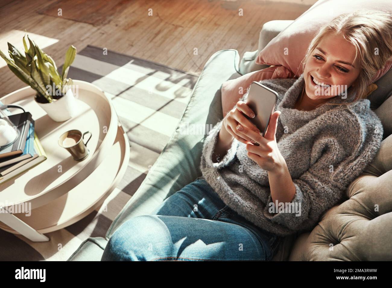 Smile, sofa and woman at home on a phone in a living room calm on ...