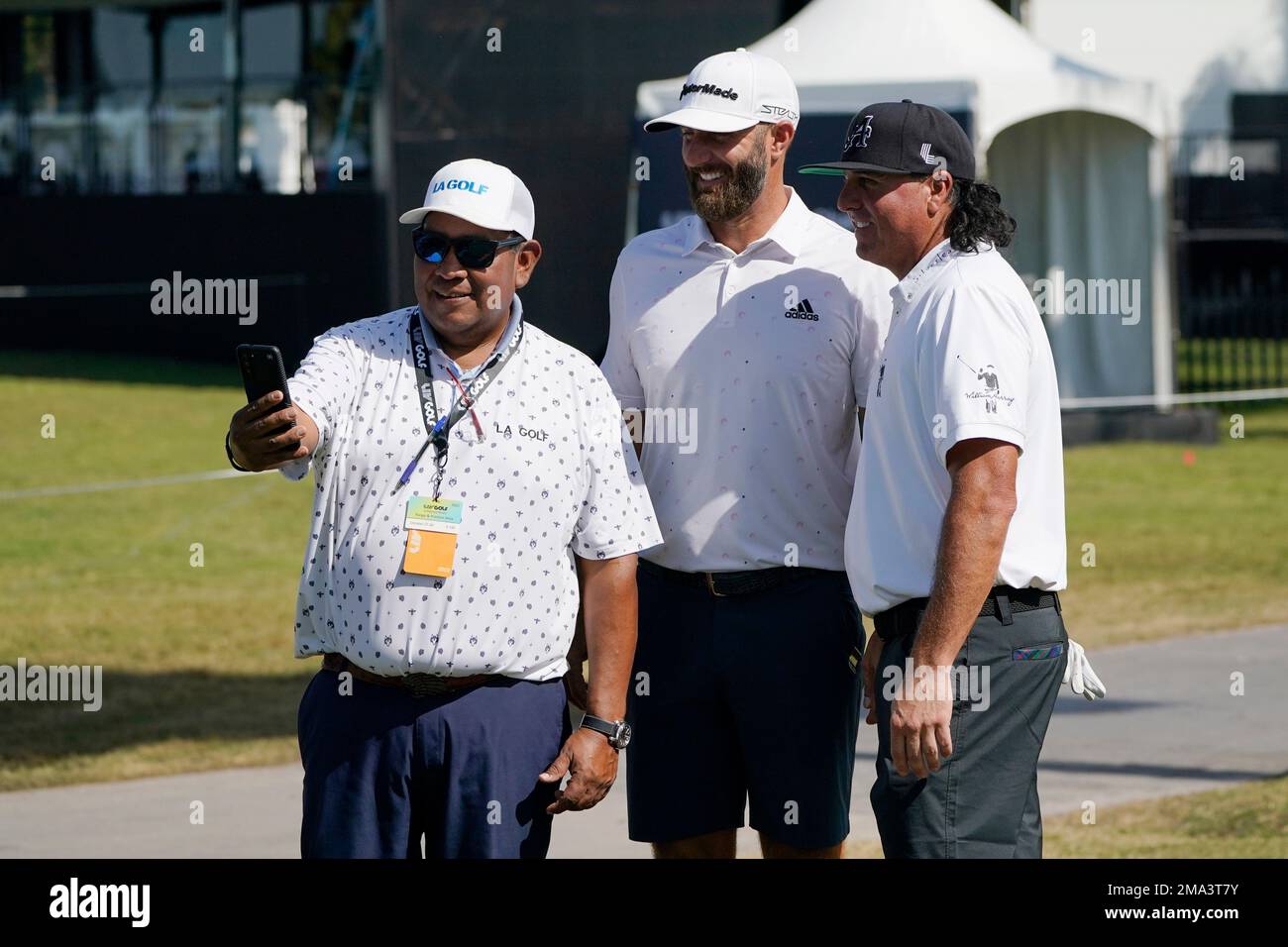 Dustin Johnson, center, and Pat Perez, right, pose for a photo during a ...