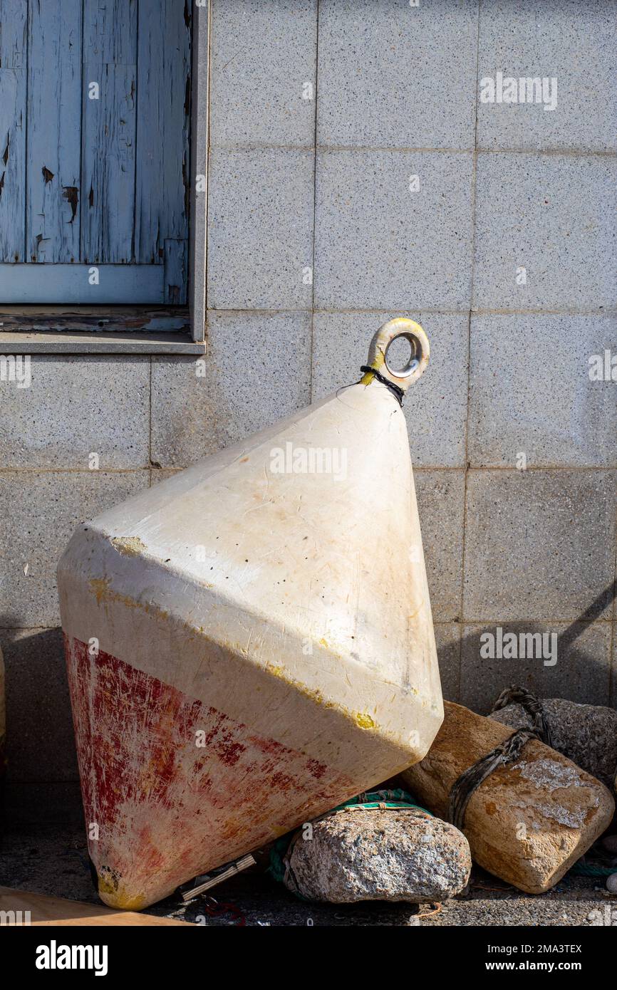 Large white and red marine buoy above ground in the fishing port of the ...