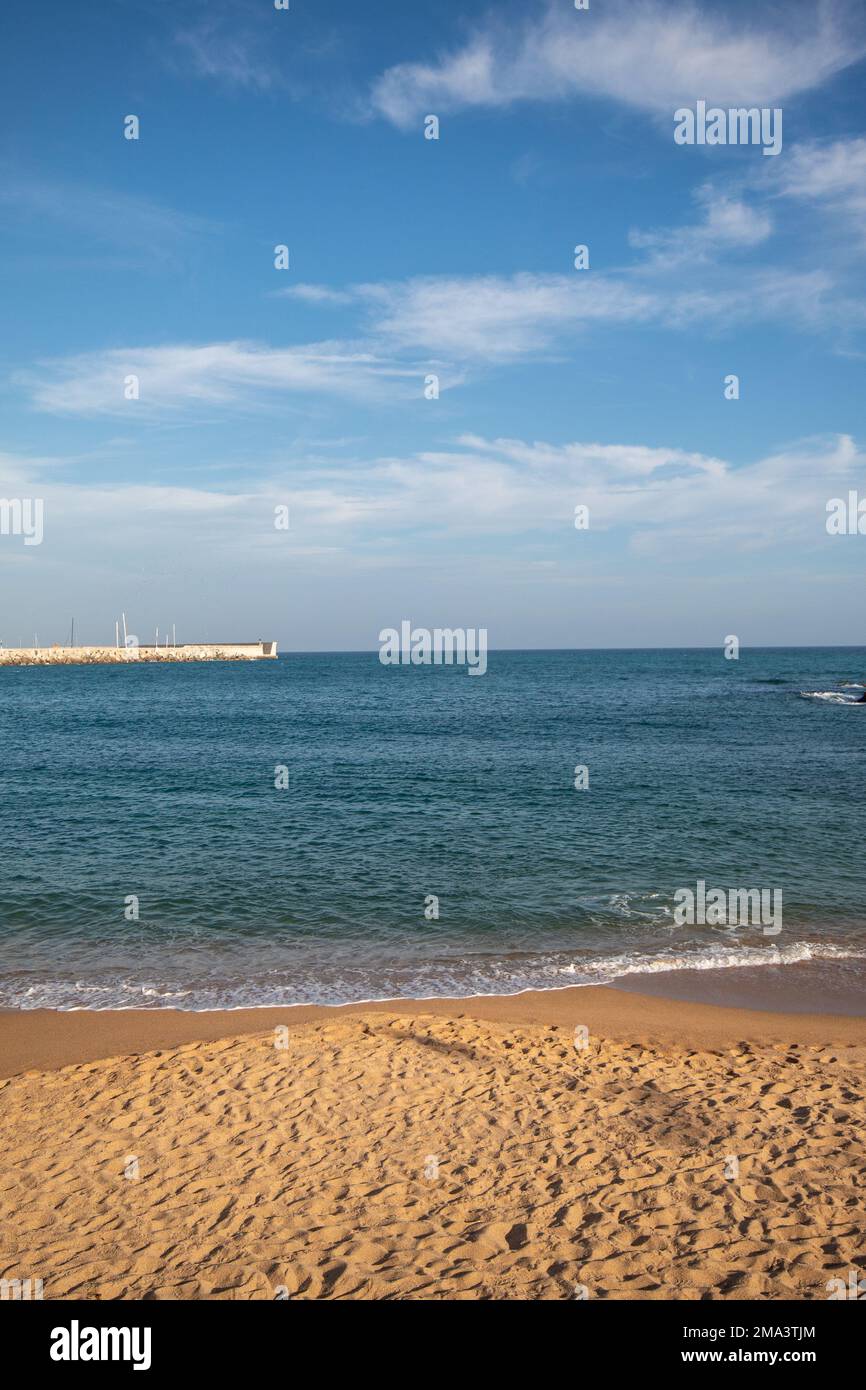 A wave blue sea ending its journey on the fine sand of the shore of the ...