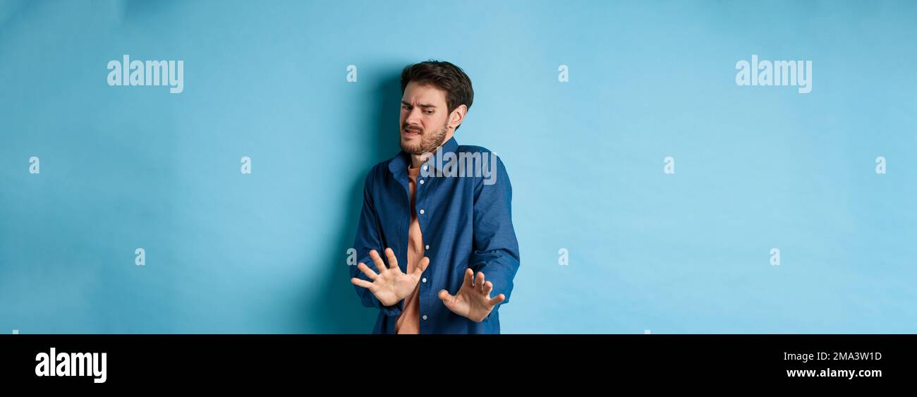 Image of man cringe and look at something disgusting, step back from ...