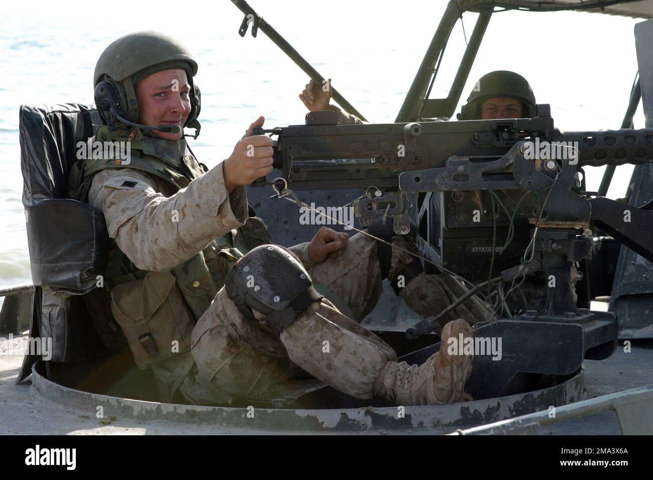 A US Marine Corps (USMC) troop sits patiently manning an M2.50caliber ...