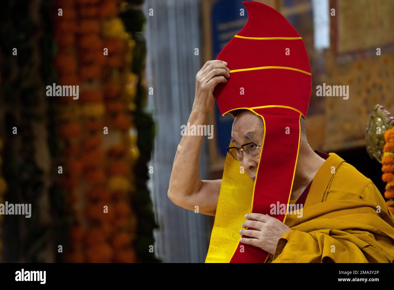 Tibetan spiritual leader the Dalai Lama wears a ceremonial hat as he ...