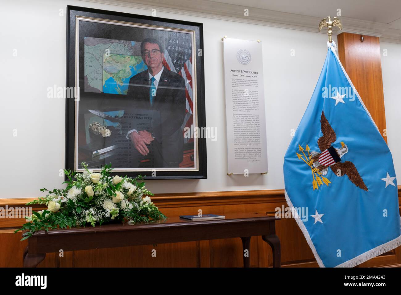 A condolence book and flowers are placed near the portrait of Defense ...