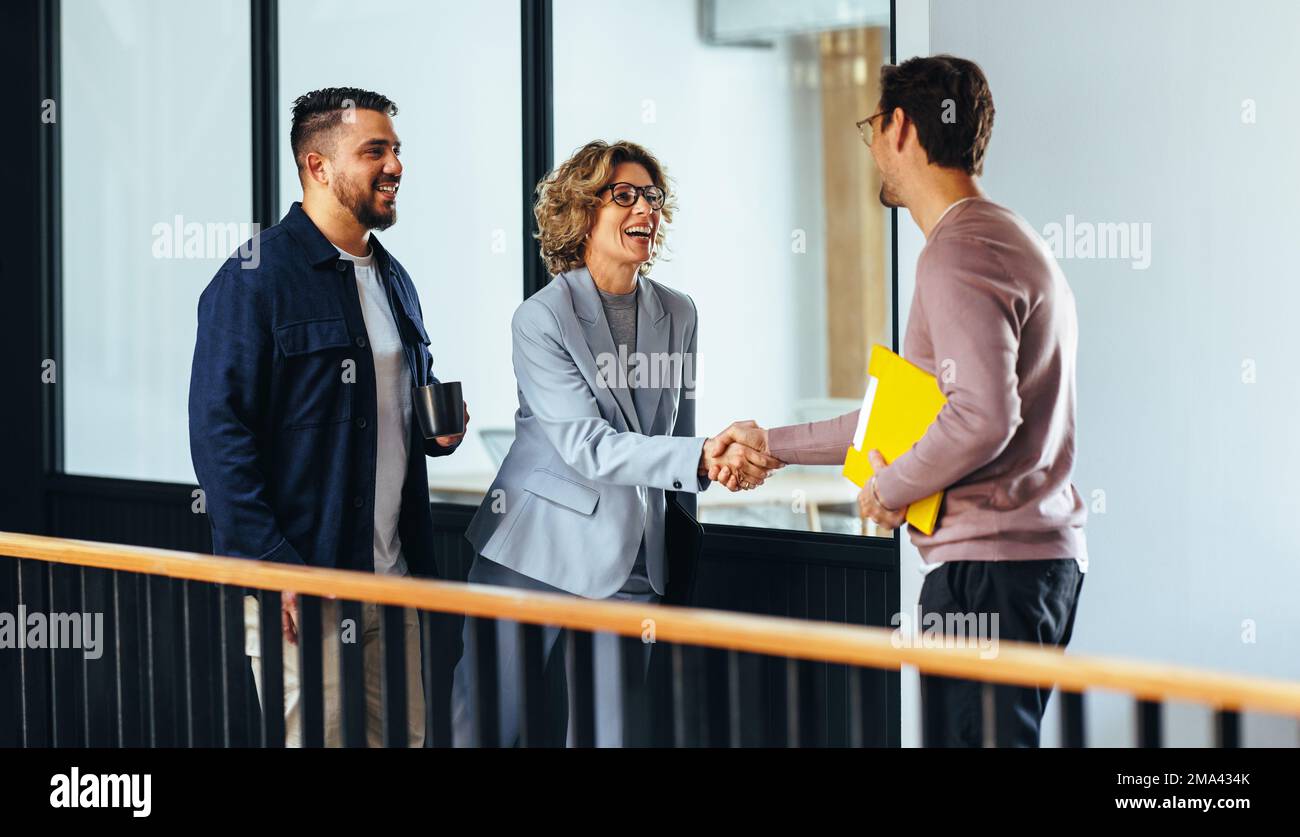 Professional woman shaking hands with a new employee in an office ...