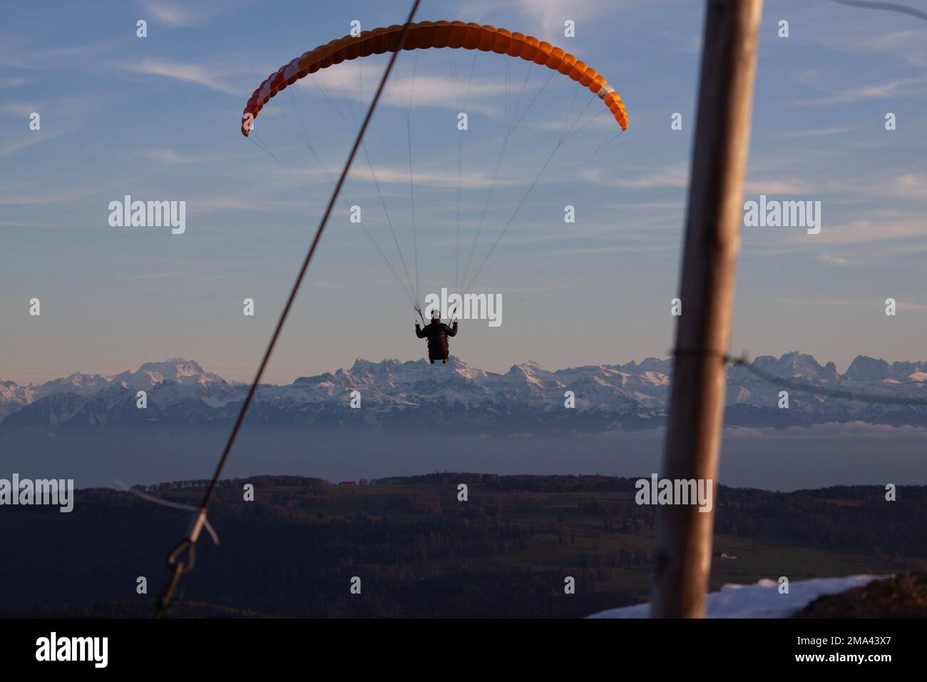 Paragliders flying over the Jura mountains with snowy Alps in the ...
