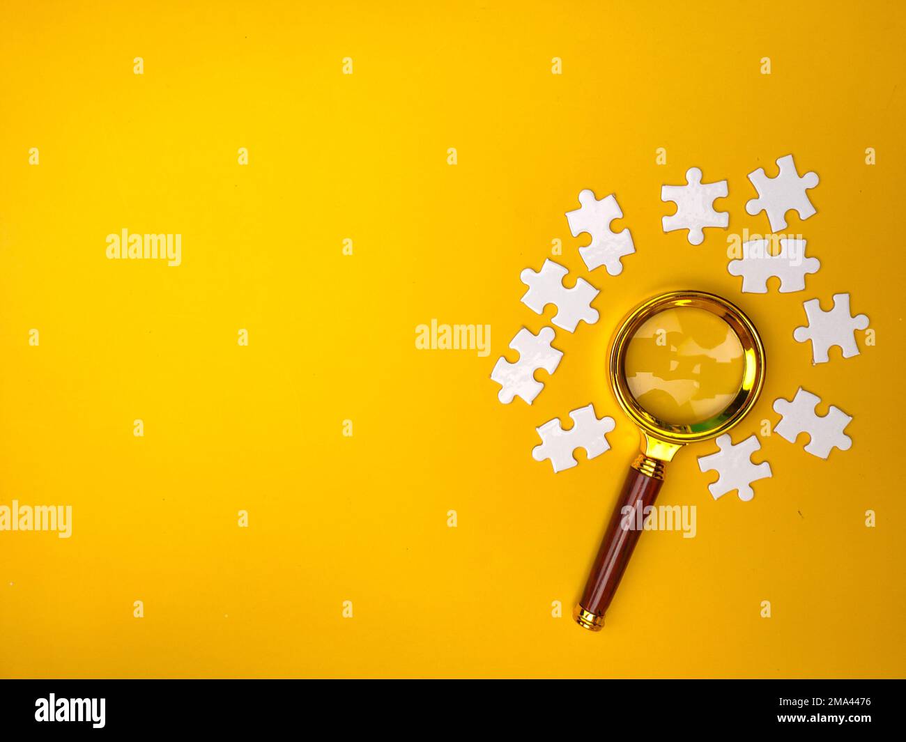 Magnifying glass searching missing puzzle on yellow background Stock ...