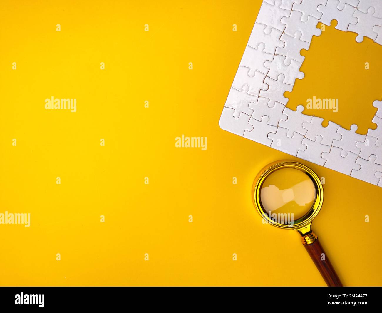 Magnifying glass searching missing puzzle on yellow background Stock ...