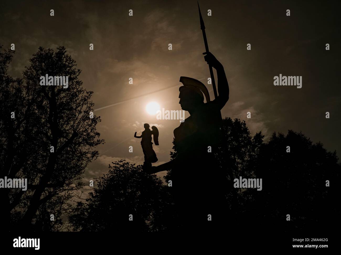 A statue of goddess Minerva is backdropped by the sun during a partial ...