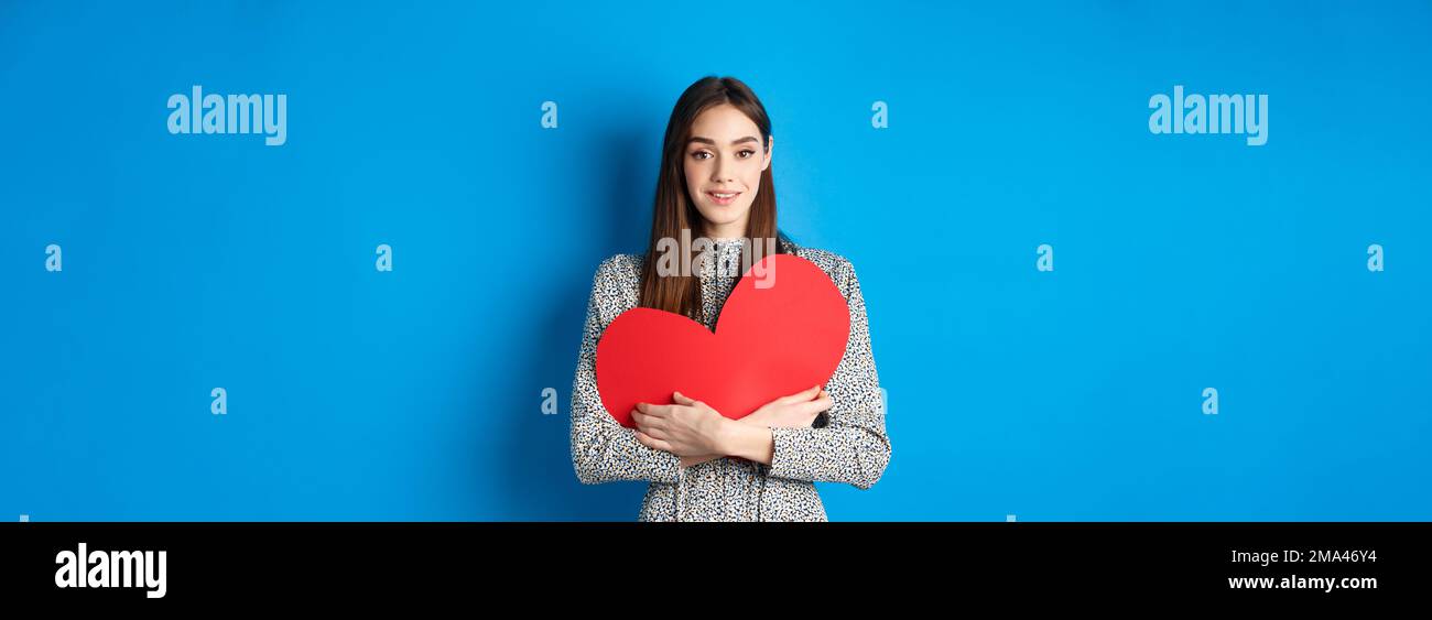 Valentines day. Attractive young woman searching for love, holding big ...