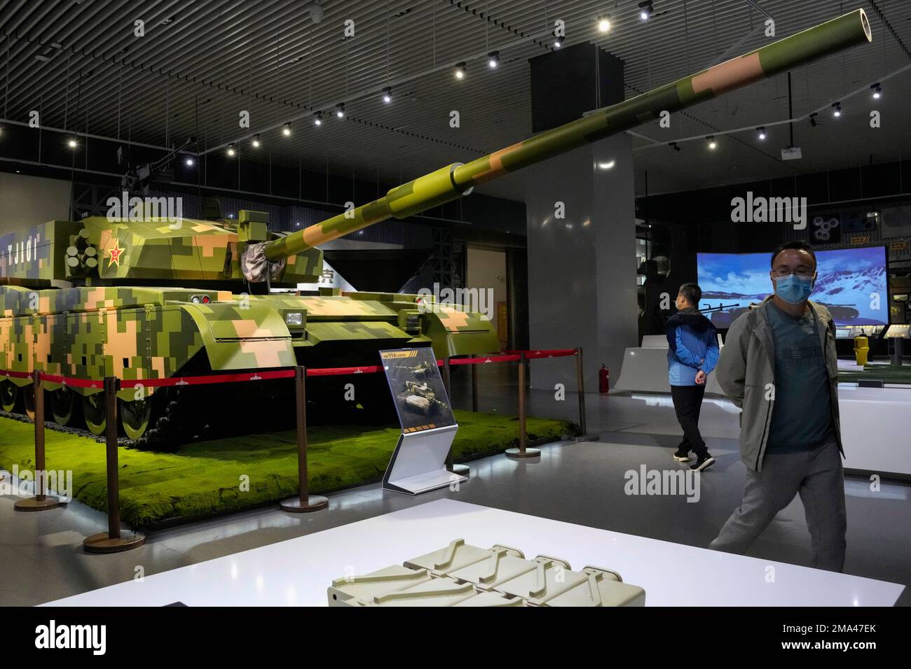 Visitors look at the newly reopened Military Museum past by a model of ...