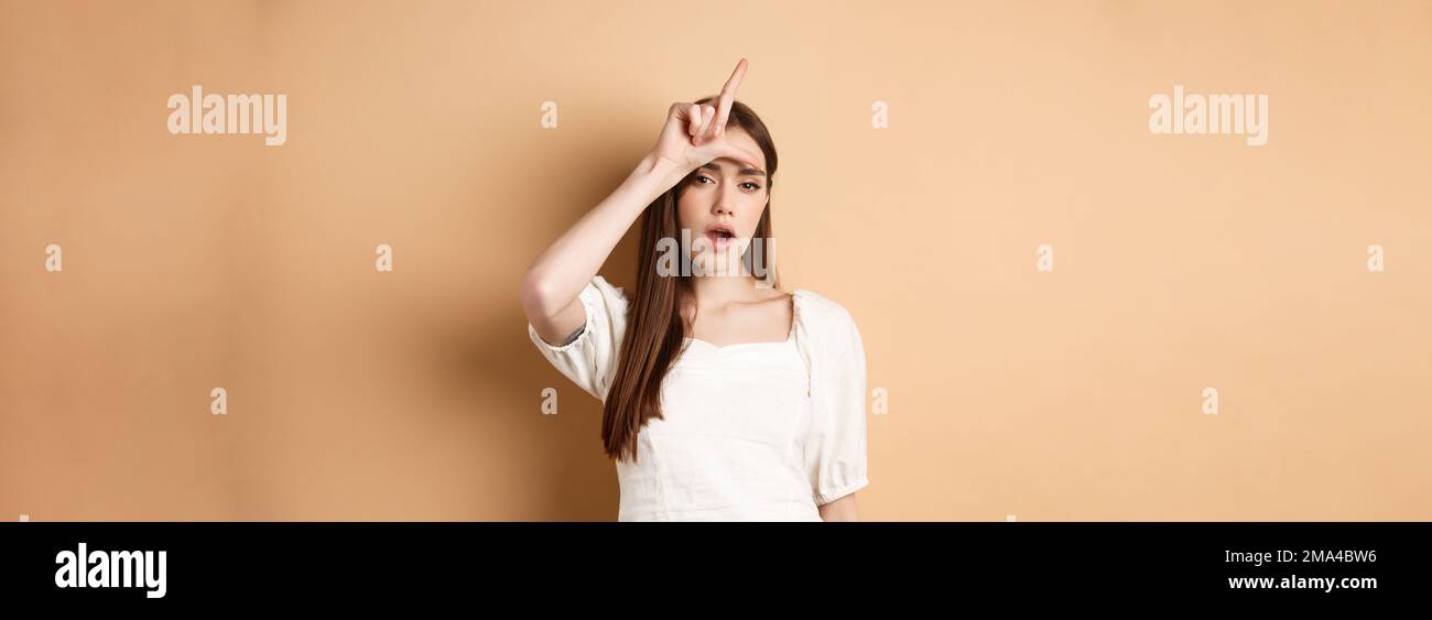 Confident woman mocking people with loser sign, being mean, standing on ...