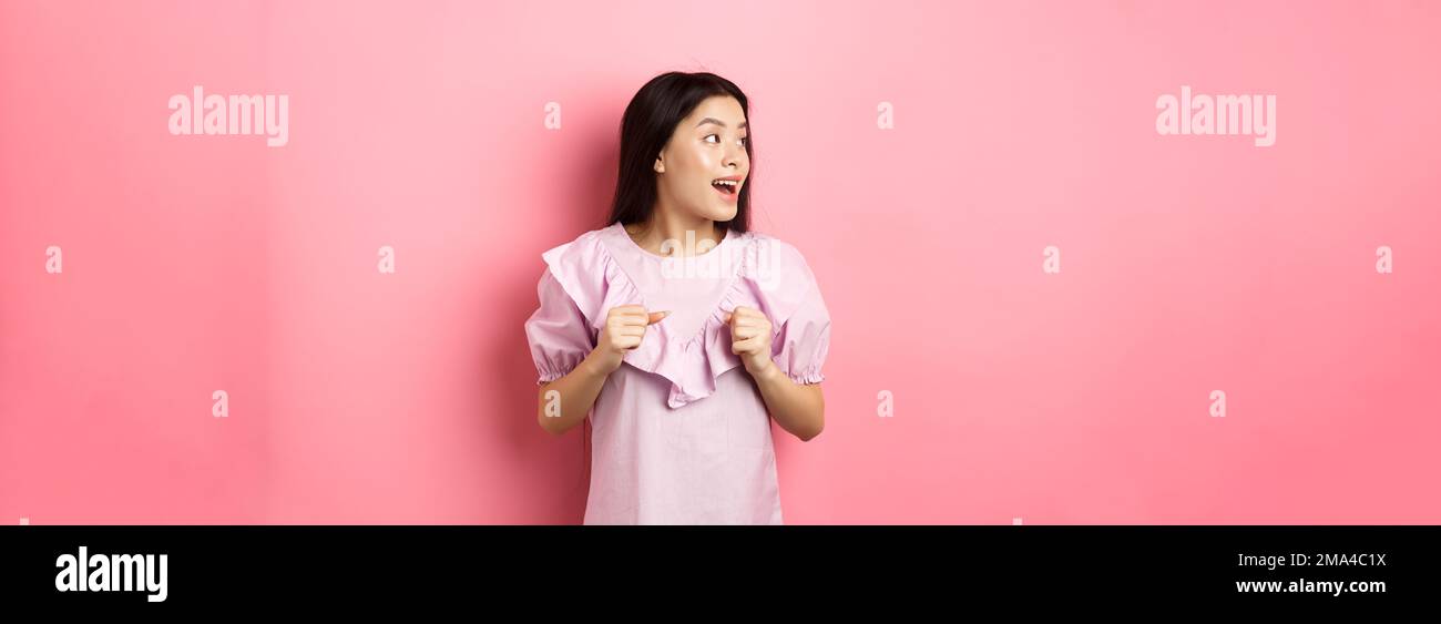 Excited asian girl look left with motivated face, smiling happy ...