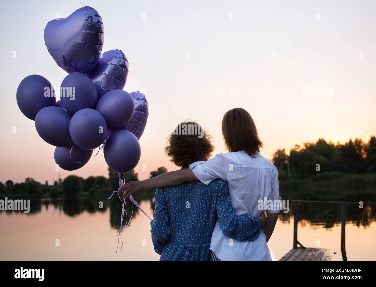unrecognizable mother and adult daughter hugging , holding a bunch of ...