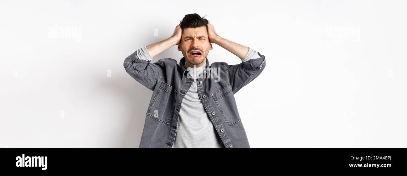 Frustrated guy crying and panicking, holding hands on head and ...