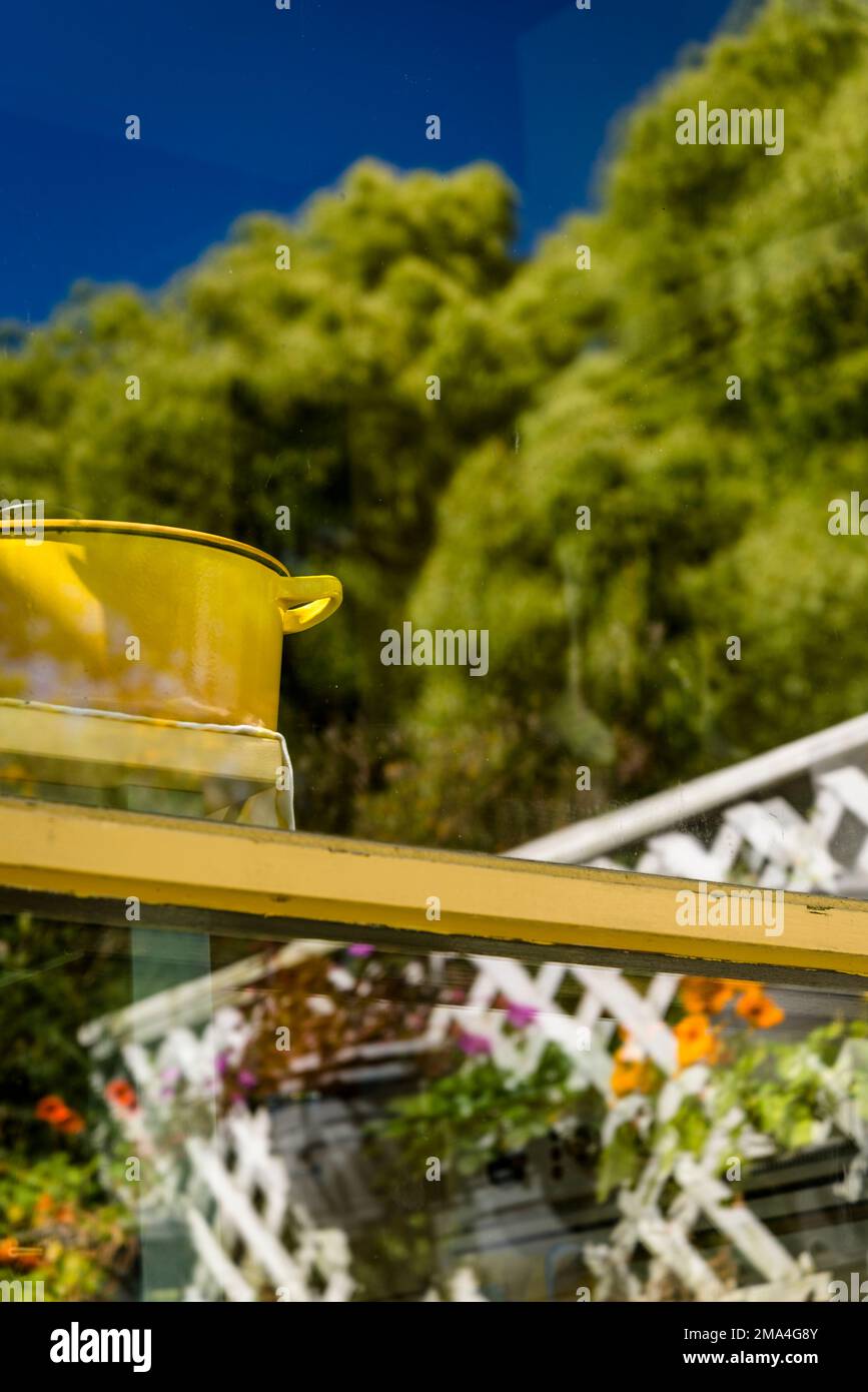 Reflection of a garden in a kitchen window with a big yellow saucepan ...