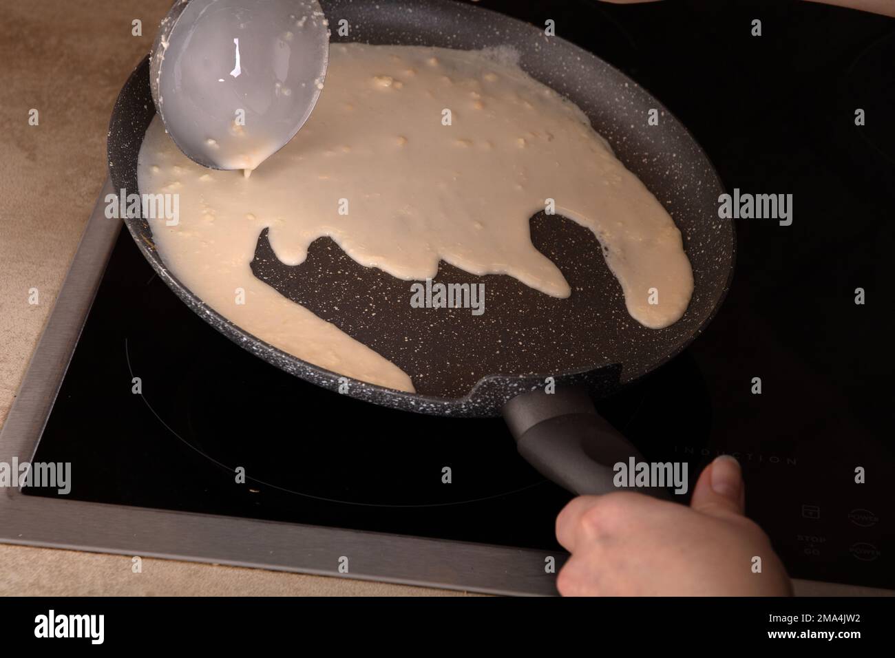 photo preparation of thin pancakes in the frame of a human hand Stock ...