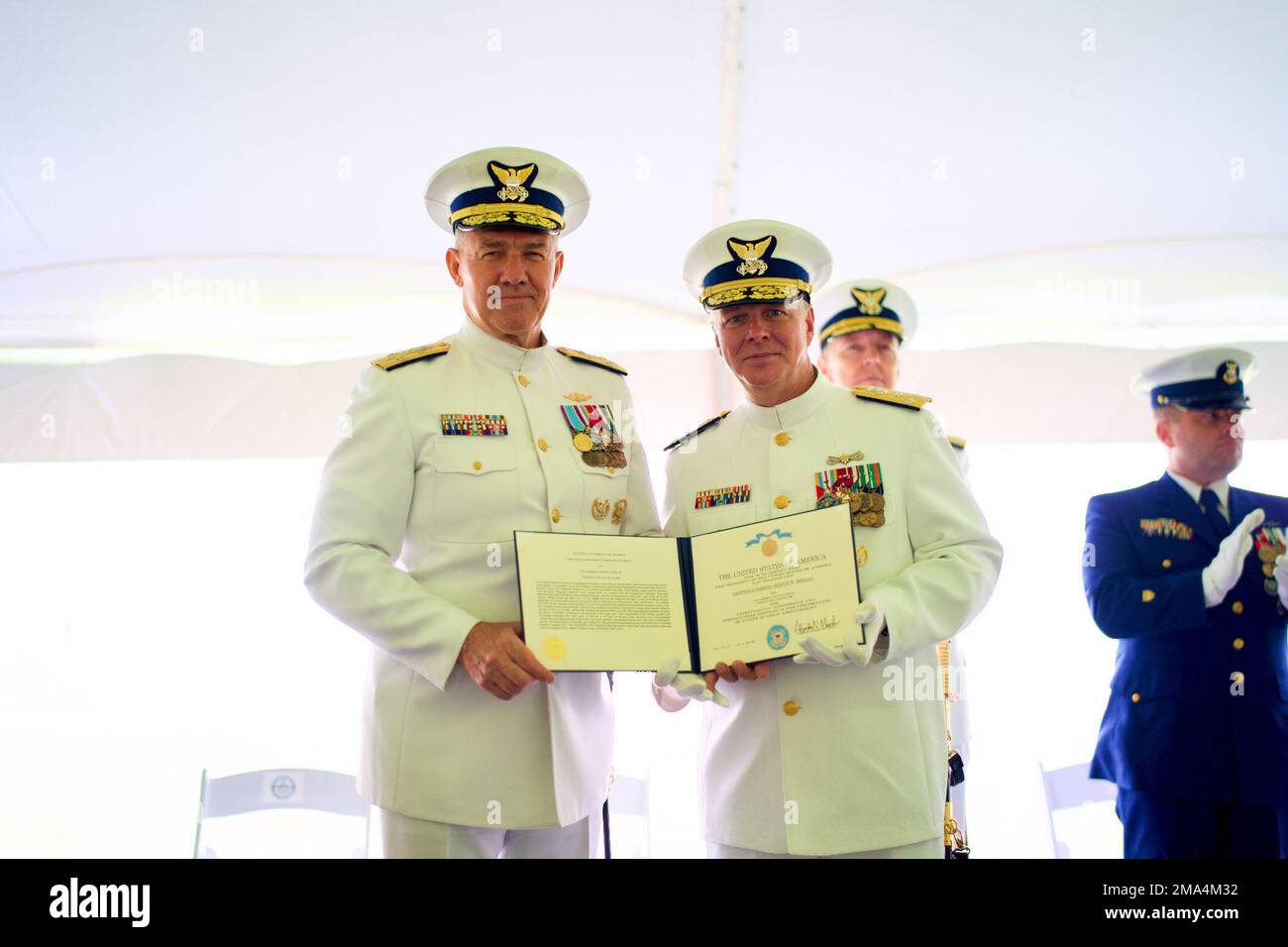 Adm. Karl Schultz, the commandant U.S. Coast Guard, presents Vice Adm. Steven Poulin, commander ...