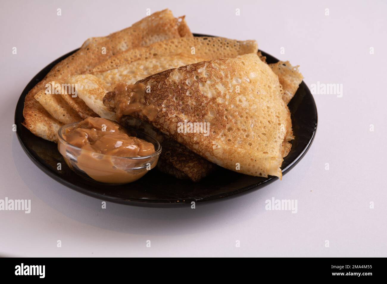 photo of pancakes lying on a plate and boiled condensed milk standing ...