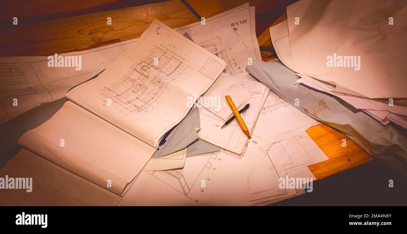 Mason's work desk in wooden cabin with pile of architectural drawings ...