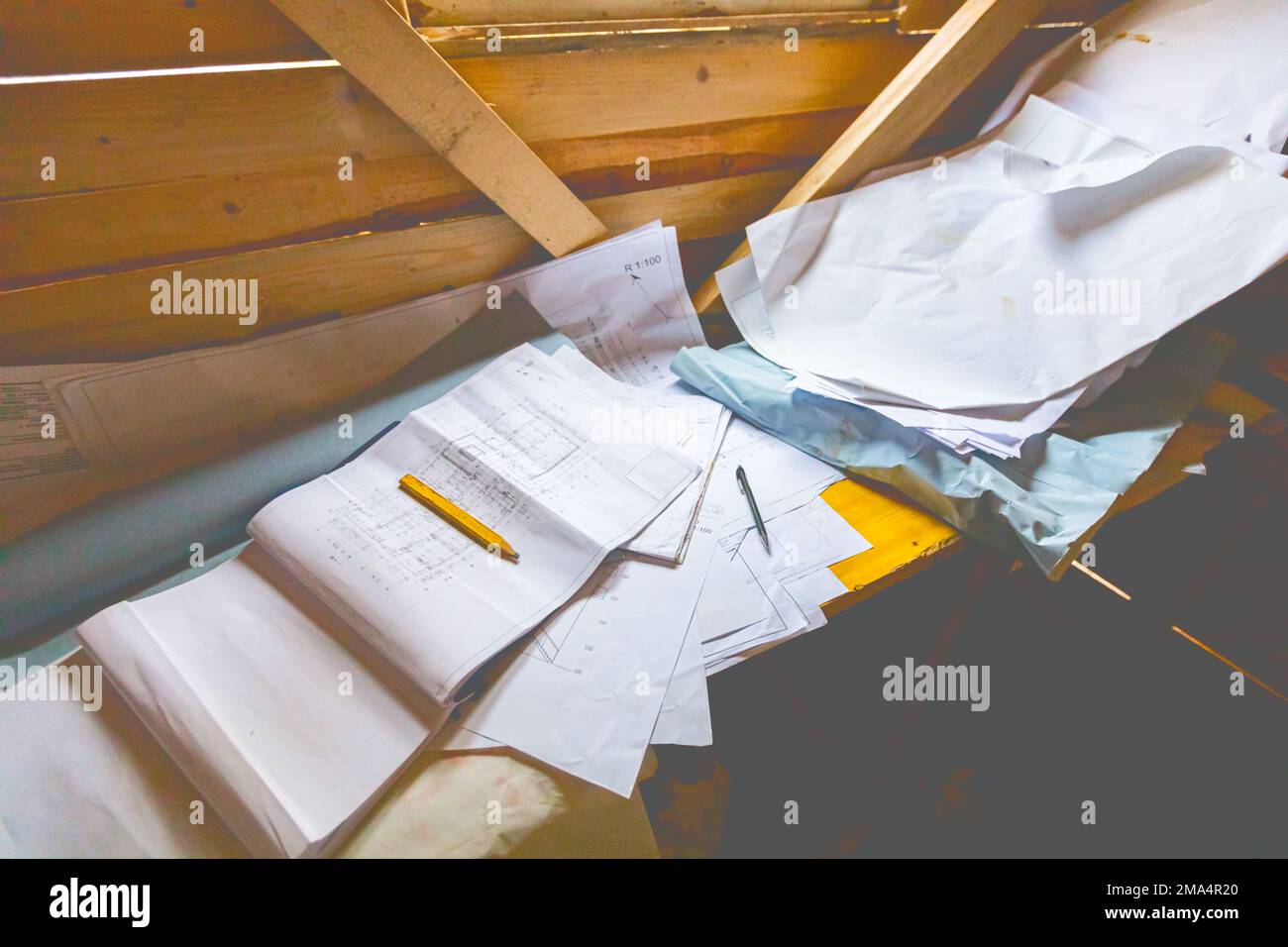 Mason's work desk in wooden cabin with pile of architectural drawings ...