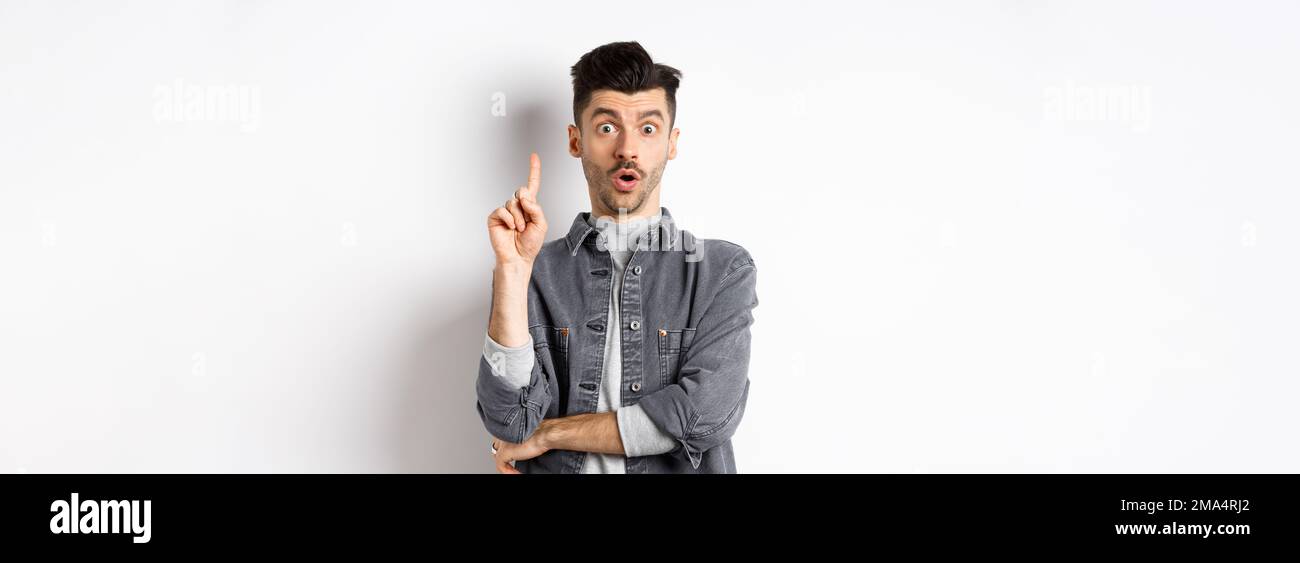 Excited bearded guy pitching an idea, raising finger up in eureka ...
