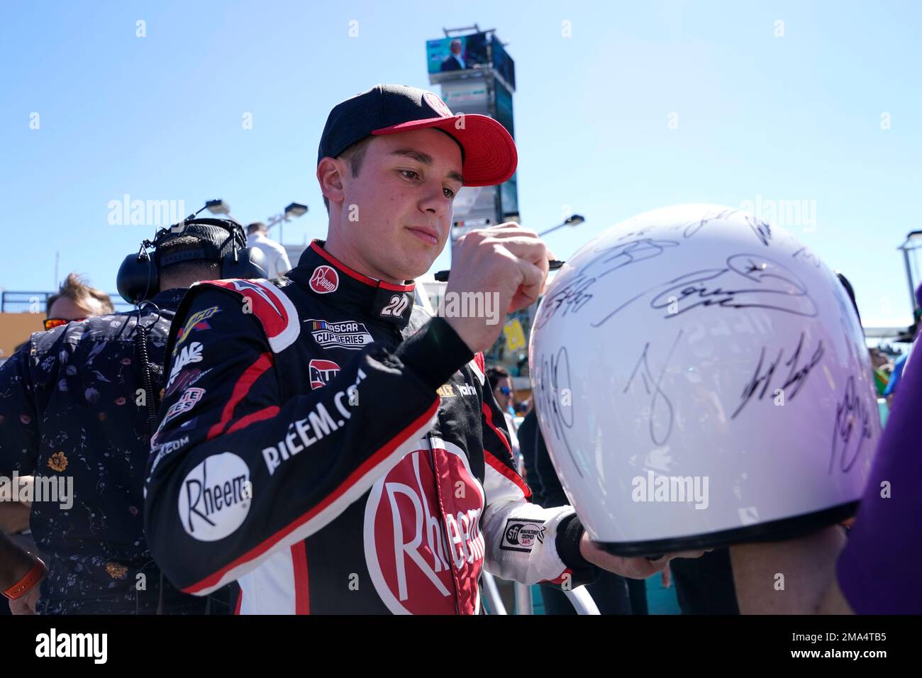 Driver Christopher Bell autographs a helmet for the NASCAR Foundation ...