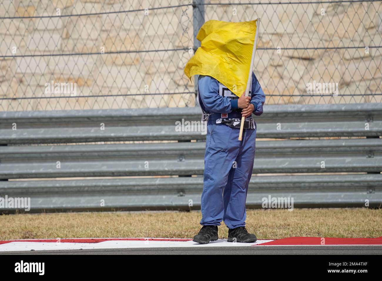 Wind whips a caution flag around a safety worker before the Formula One ...