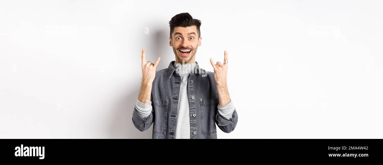 Happy and excited guy showing rock on gesture and having fun, enjoying ...