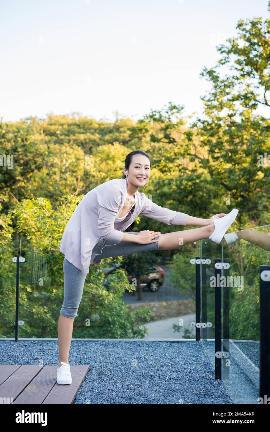 A young woman to listen to music while exercising Stock Photo - Alamy